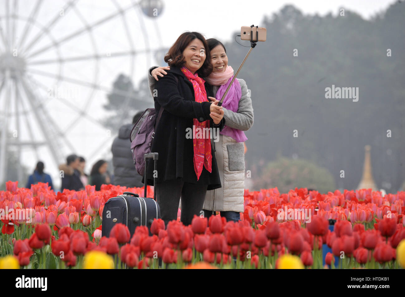 Changsha. 11th Mar, 2017. Tourists pose for pictures with the tulip ...