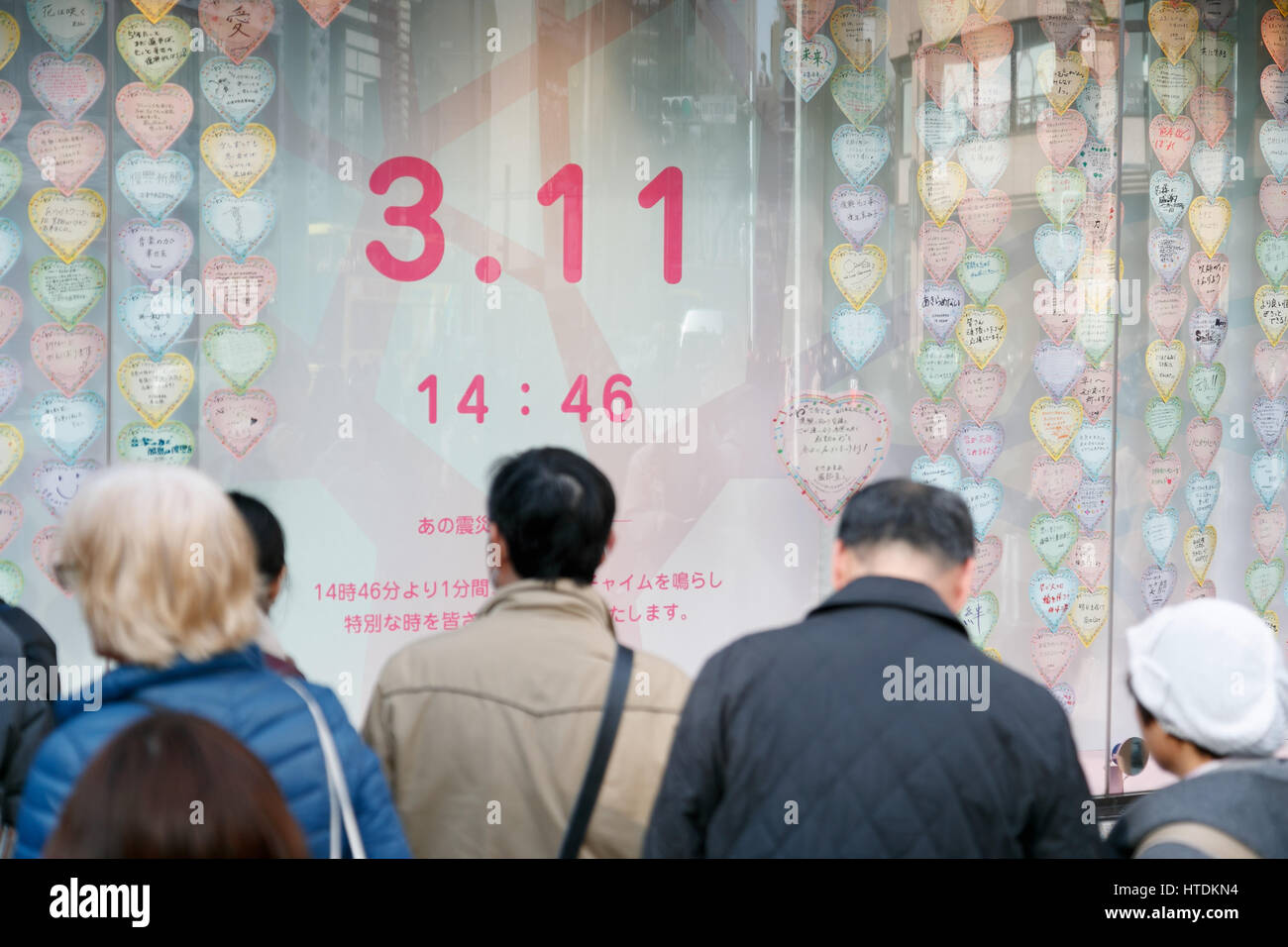 Tokyo, Japan. 11th March 2017. People look at the messages on display ...
