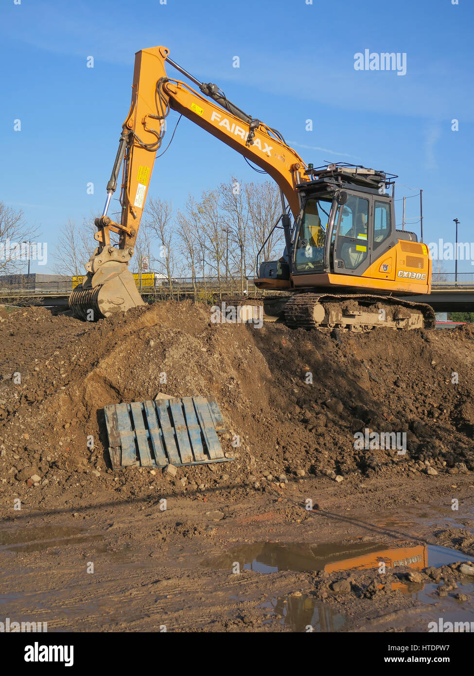 yellow digger on a building site doing construction work Stock Photo ...