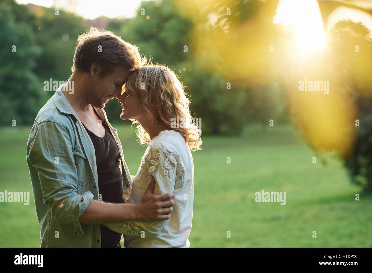 Affectionate young couple standing face to face while enjoying a ...