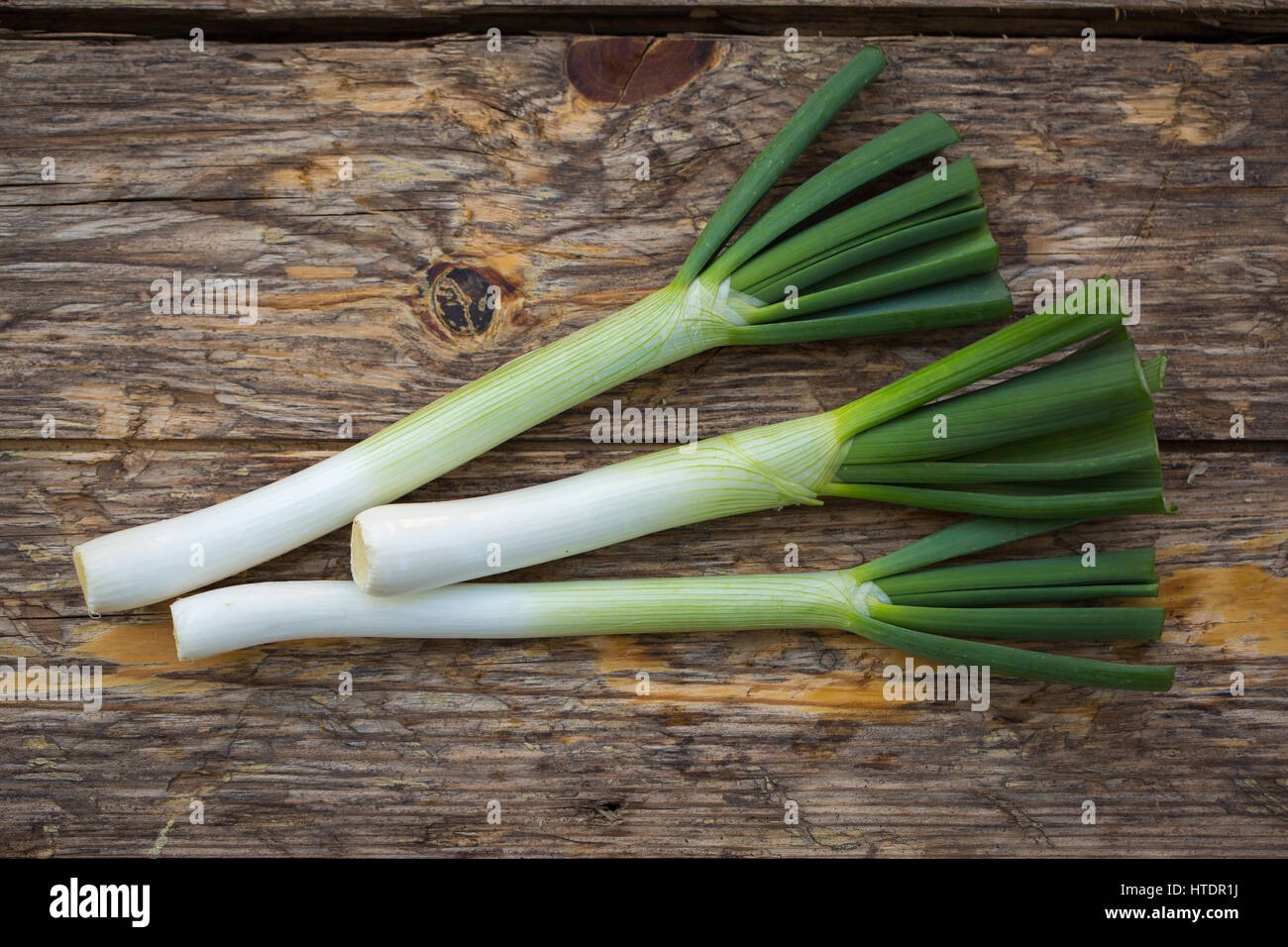 Fresh raw spring onions on a wooden board Stock Photo - Alamy