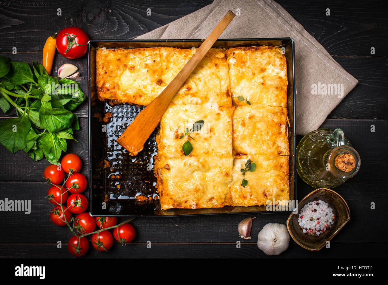 Delicious traditional italian lasagna with ingredients served on dark ...
