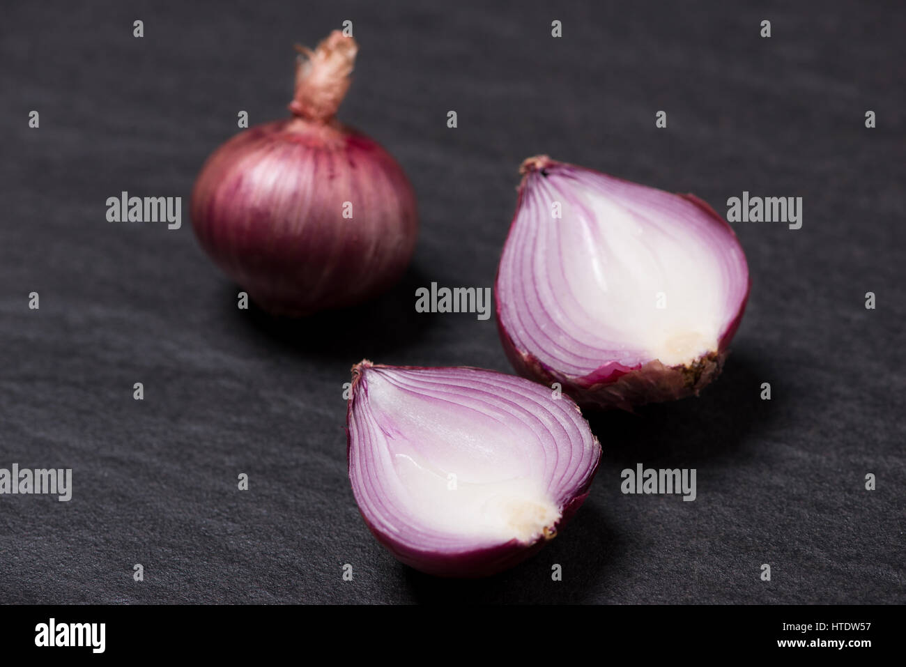Full and half cut spanish onions on dark background Stock Photo - Alamy