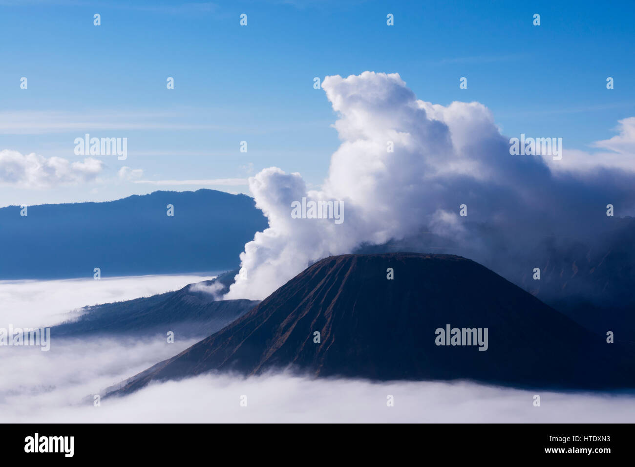 White smoke coming out of volcanoes surrounded by white clouds of mist ...