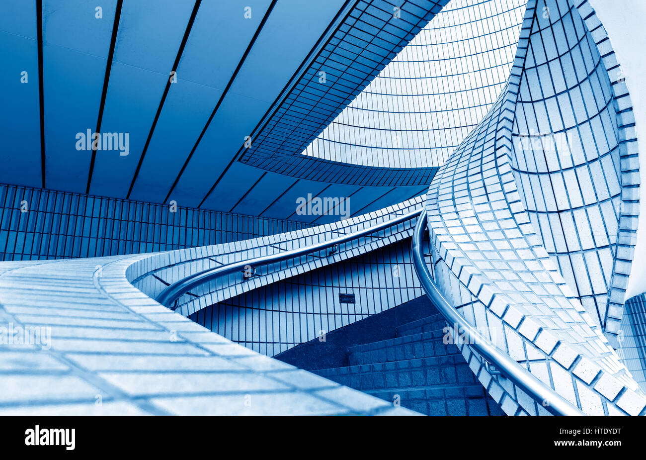 Curved rotating staircase, modern building Partial, blue tinted figure ...