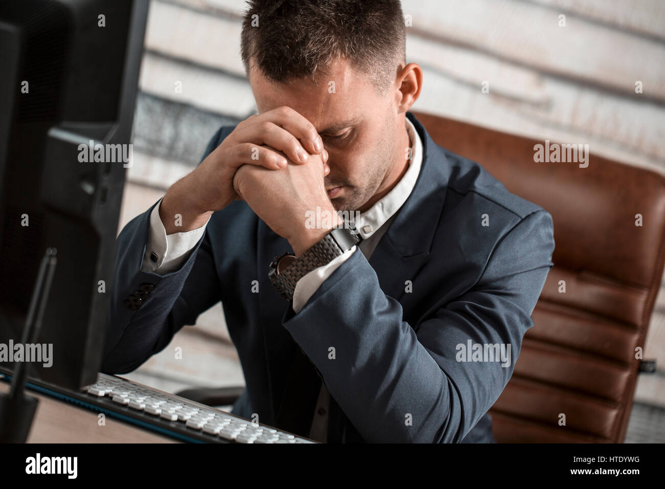 Tired business man at workplace in office holding his head on hands ...