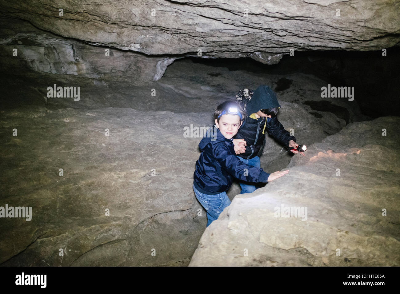 Children explore underground cavern Stock Photo - Alamy