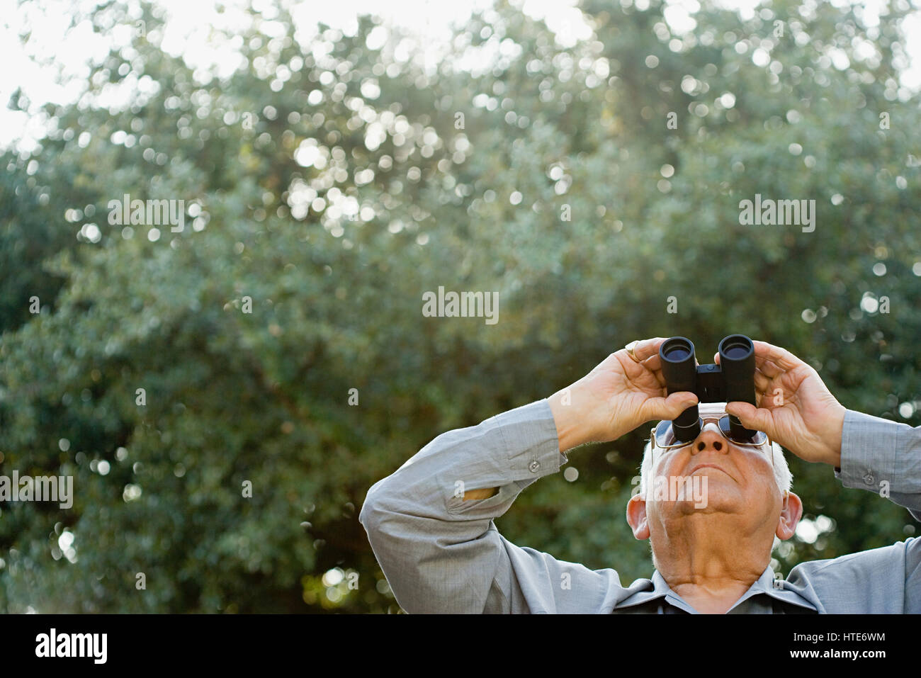 Old man looking through telescope hi-res stock photography and images ...