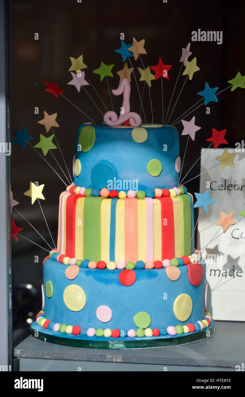 Colourful birthday cake on display in a shop window Stock Photo - Alamy