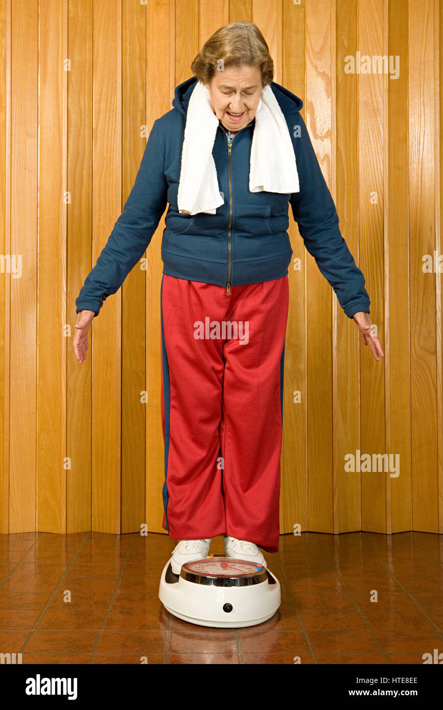 Senior woman stood on scales Stock Photo - Alamy