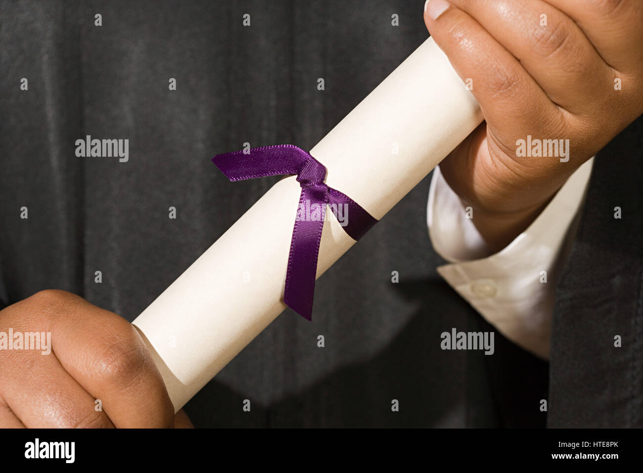 Graduate holding diploma Stock Photo - Alamy