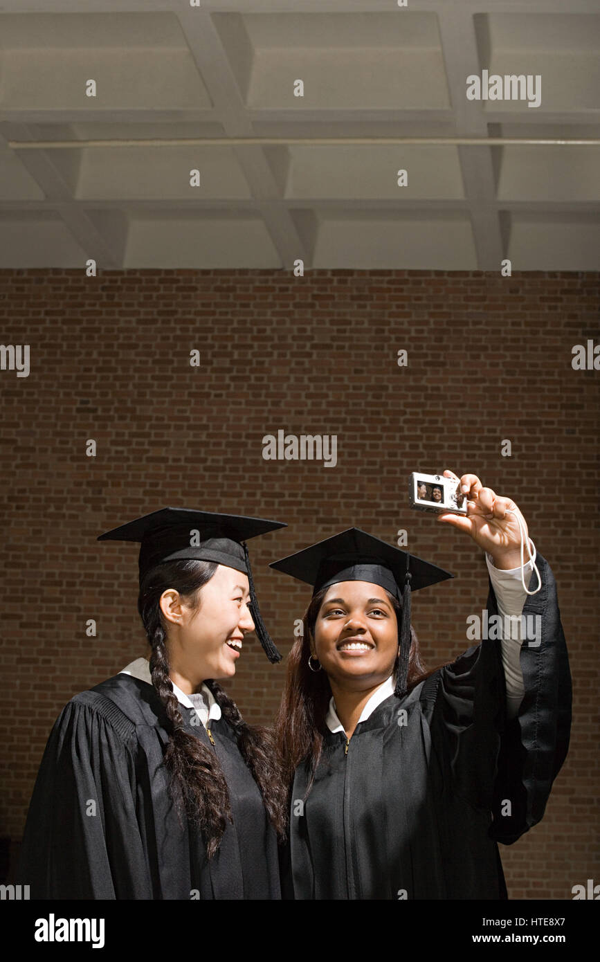 Two female graduates taking a photograph Stock Photo - Alamy
