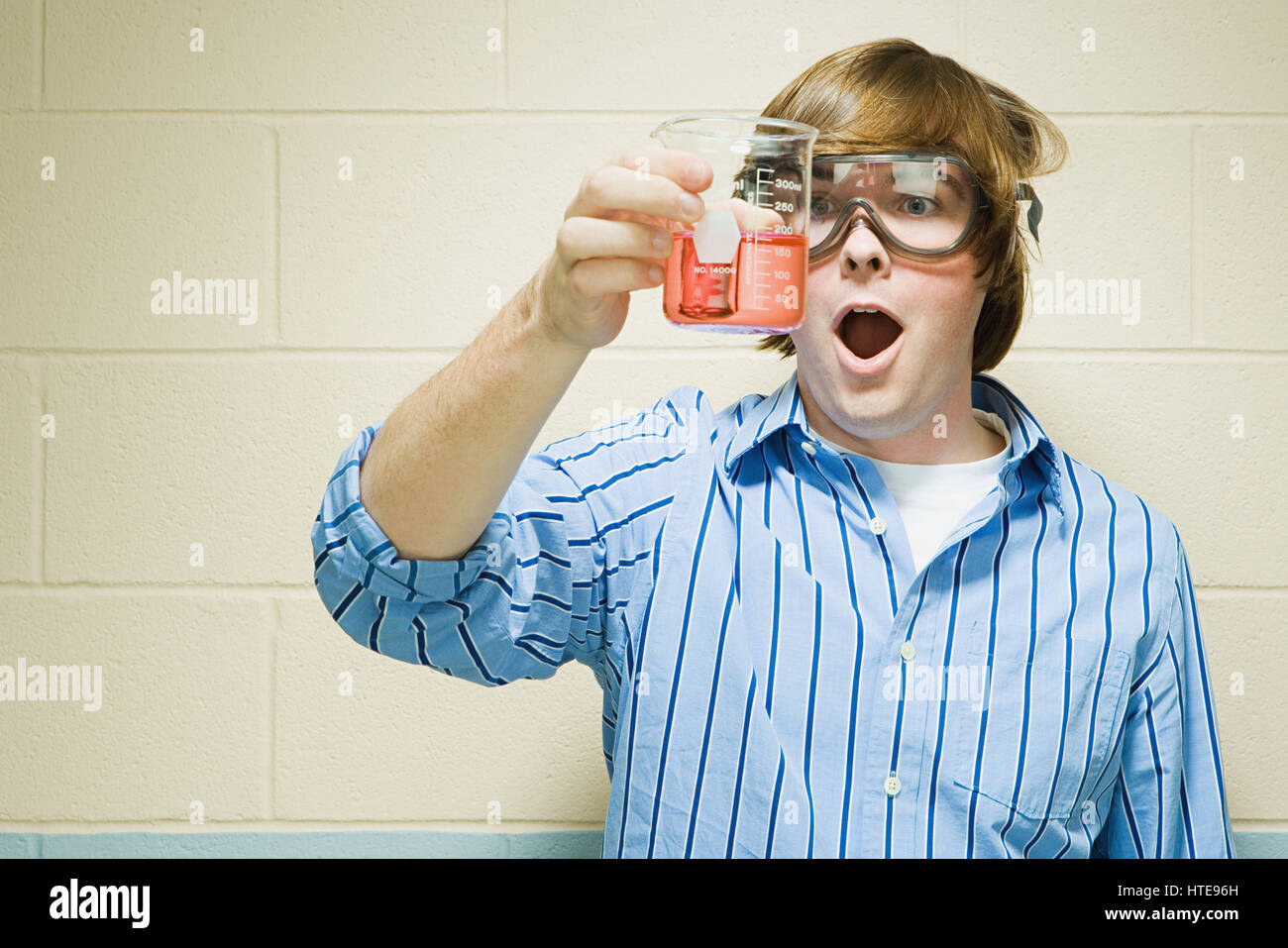 Male student holding flask of chemicals Stock Photo - Alamy