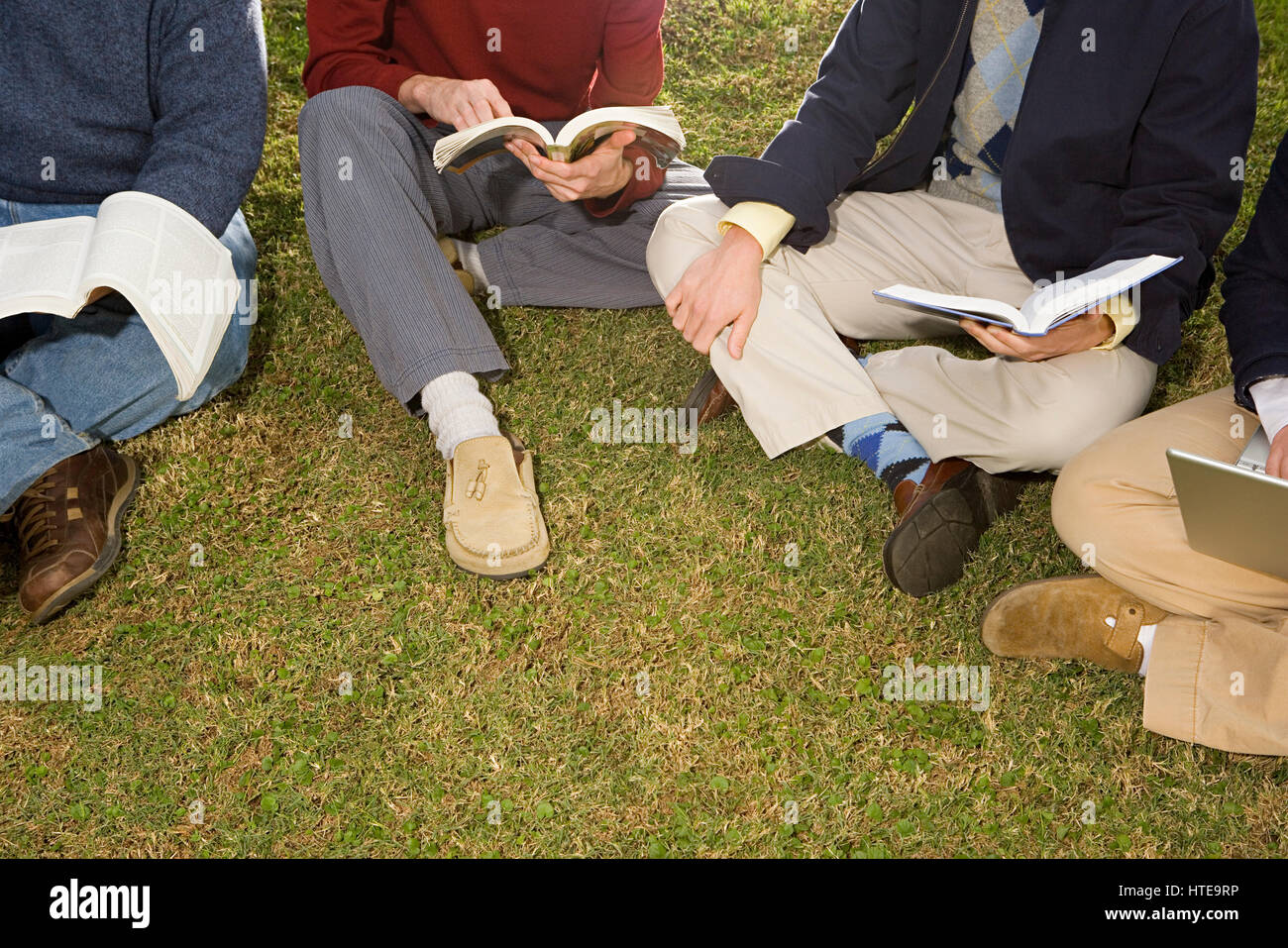 Four students sat outdoors Stock Photo - Alamy