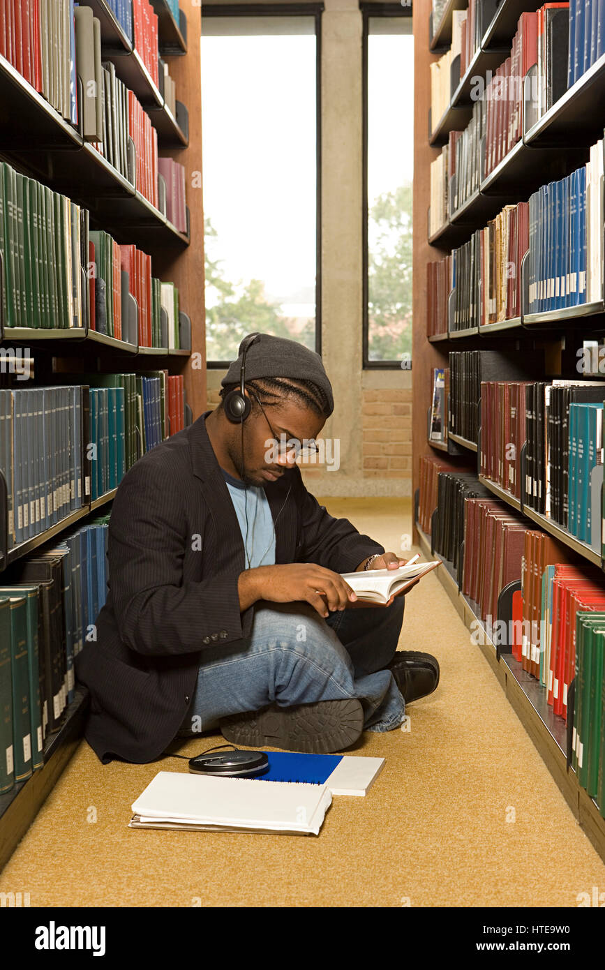 Male student reading in the library Stock Photo - Alamy