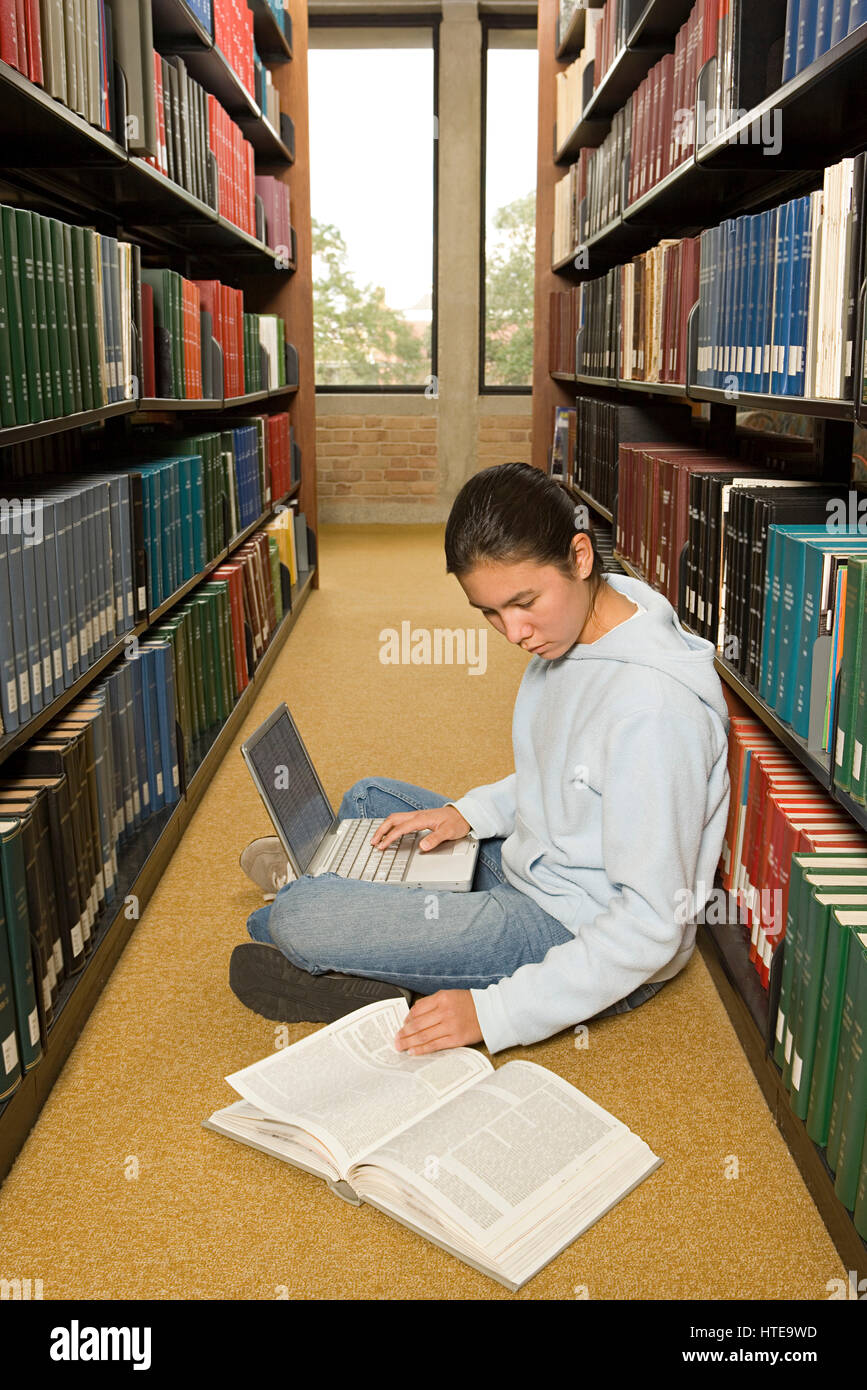 Female student working in the library Stock Photo - Alamy