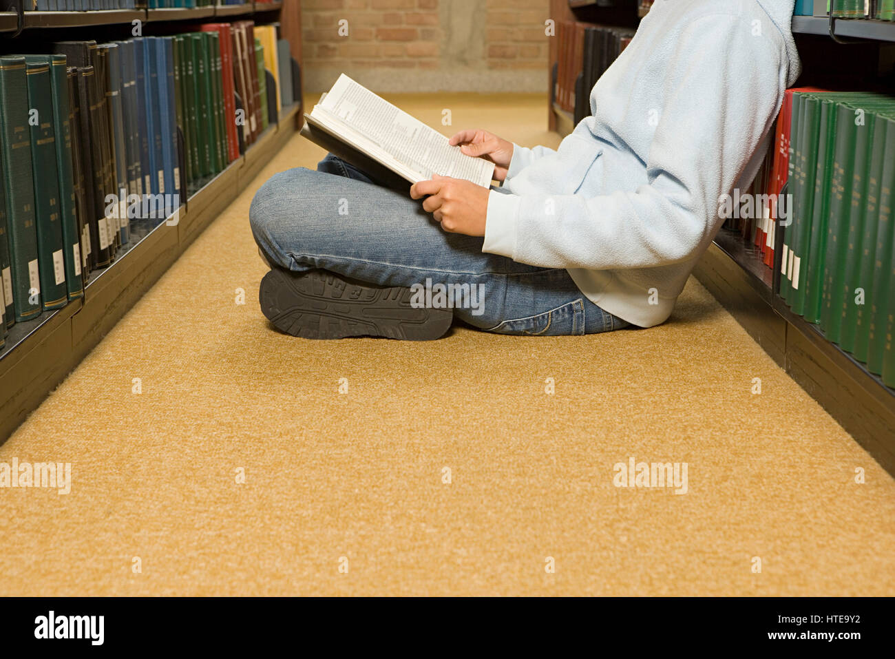 Female student reading in the library Stock Photo - Alamy