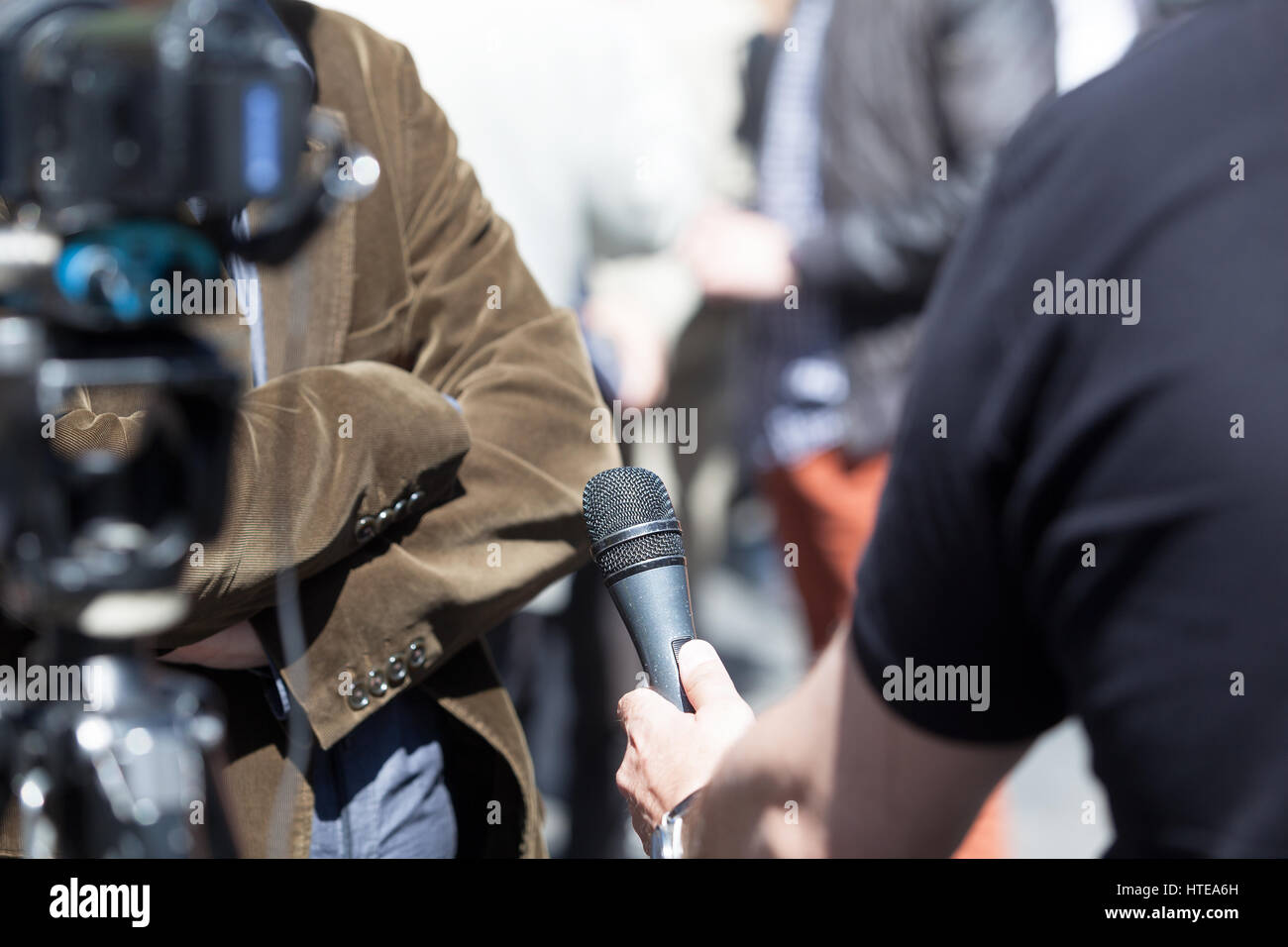 Reporter holding microphones conducting TV interview Stock Photo - Alamy