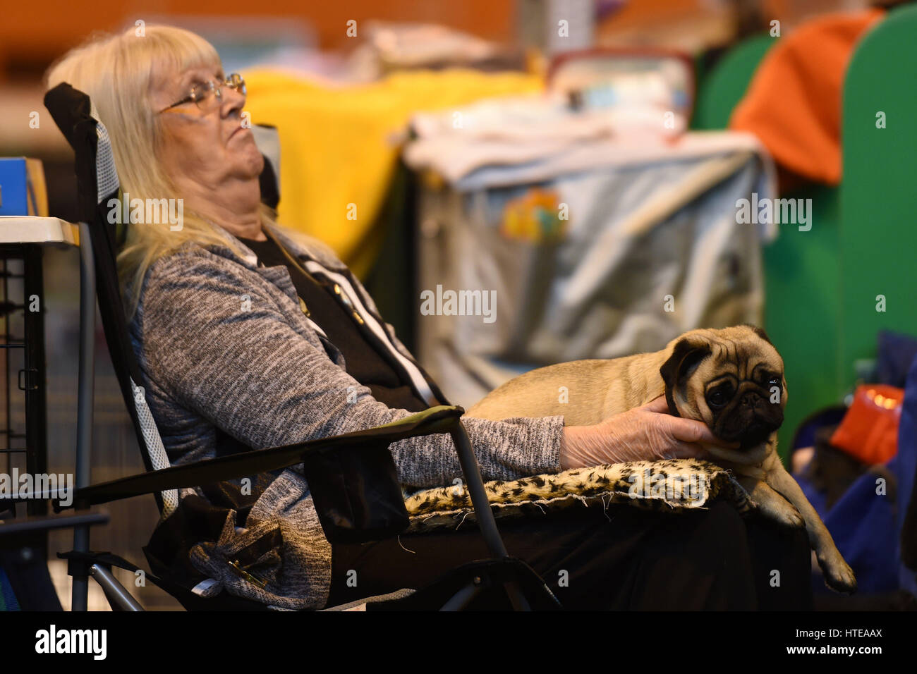 A woman sleeps with a pug on her lap during day two of Crufts 2017 at ...