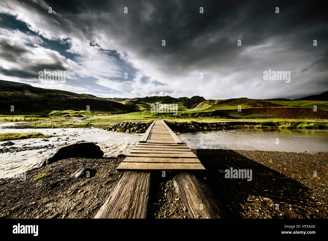 A bridge is leading to the beautiful Icelandic landscape with volcanic ...