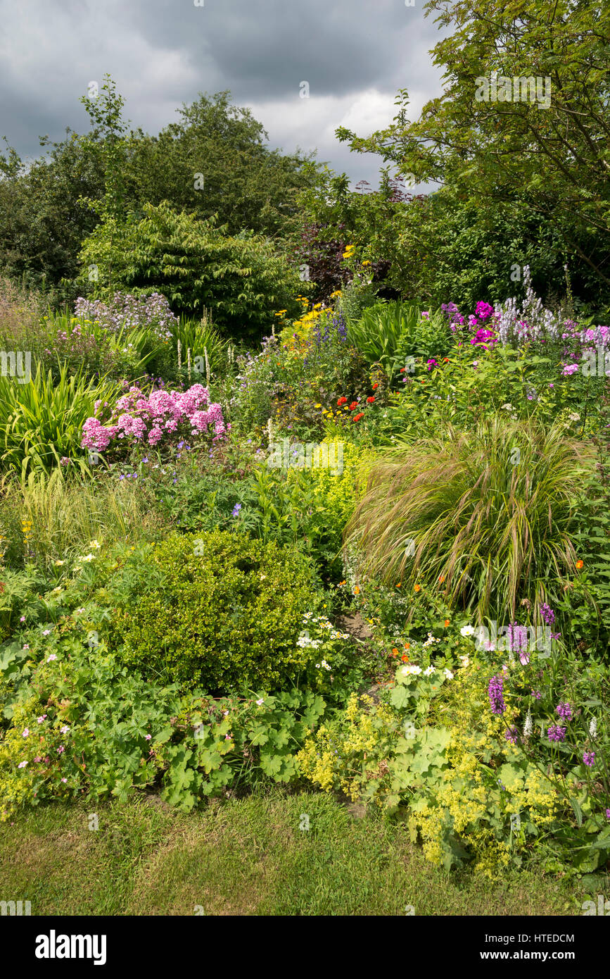 Colourful flower borders in a cottage garden style. Mixed planting of ...