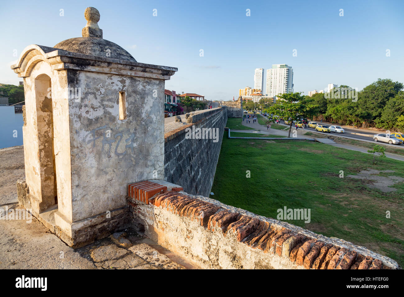 A colonial turret and wall with modern buildings in the background in ...
