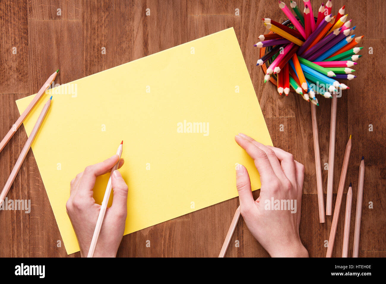 Girl hands drawing, blank yellow paper and colorful pencils on old ...