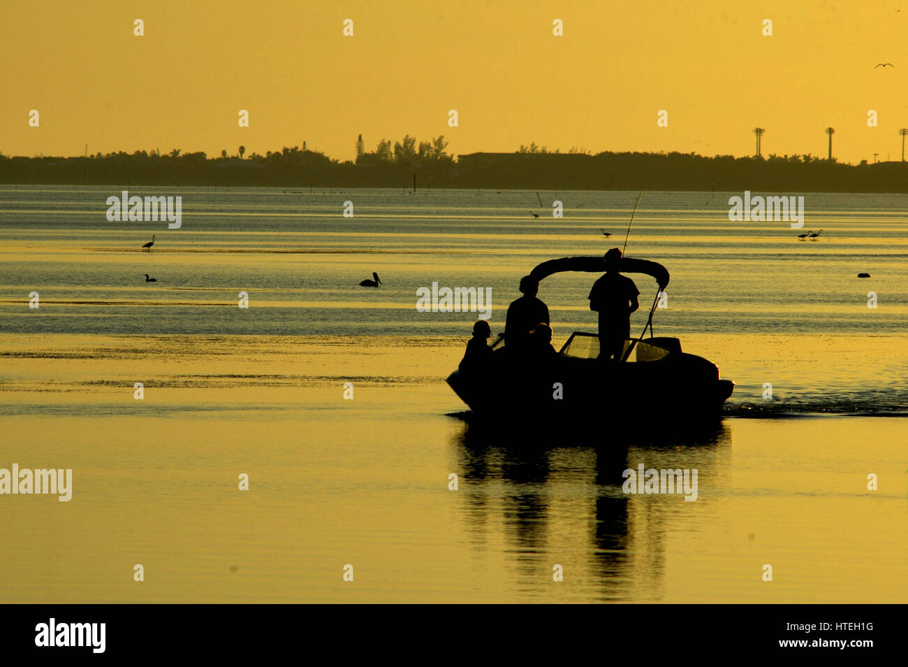 sunset back lit silhouette boat in water Stock Photo - Alamy
