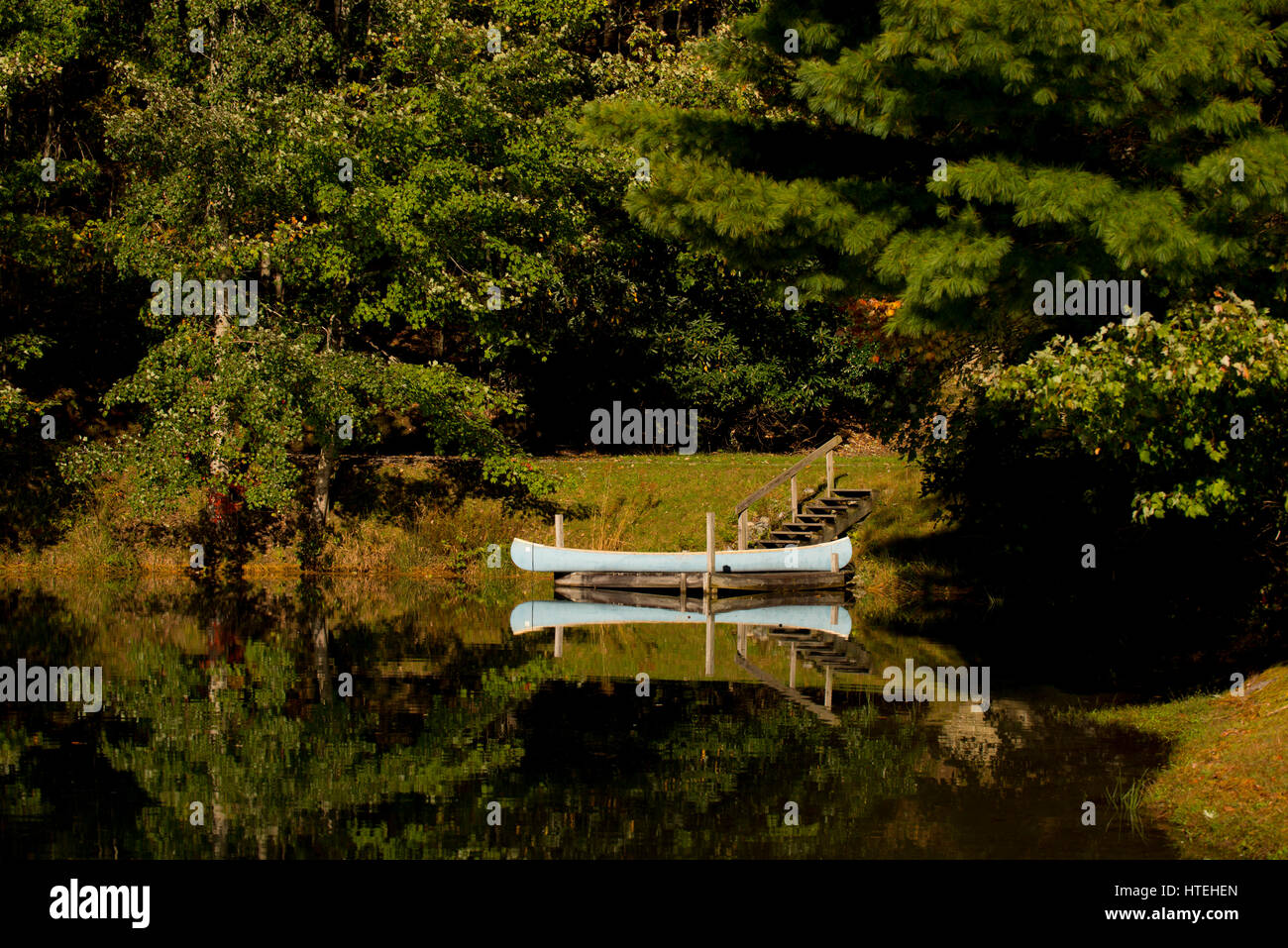canoe with reflection in lake at dock Stock Photo - Alamy