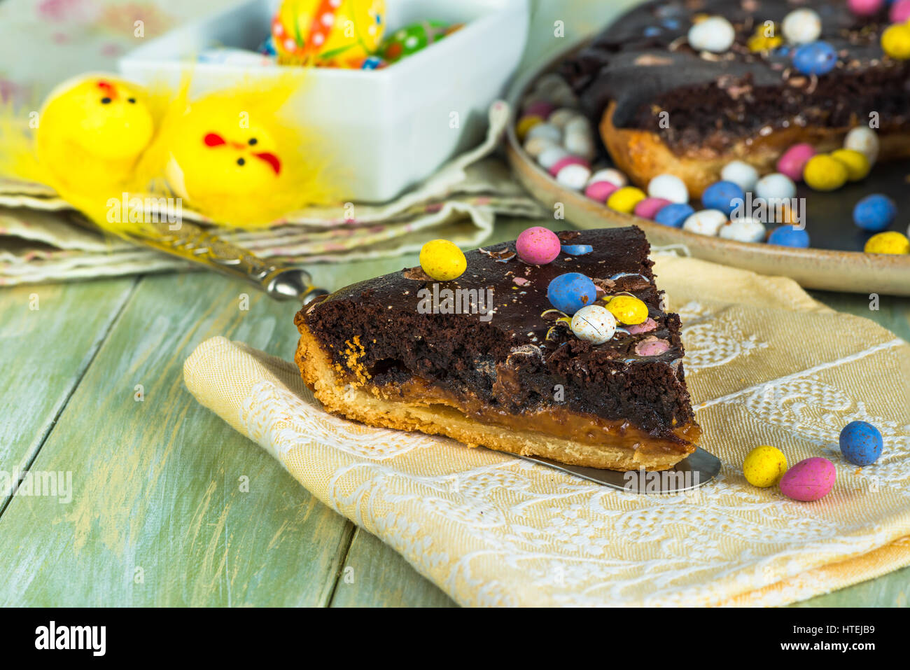 A slice of chocolate and salted caramel Easter tart garnished with mini ...