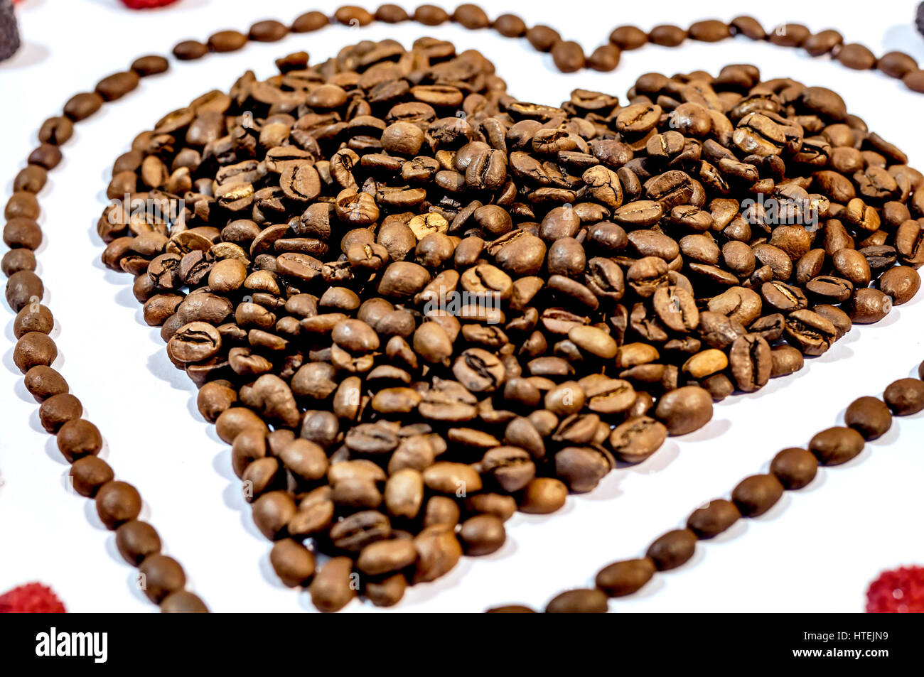 Coffee beans in heart shape with line around heart on white background ...