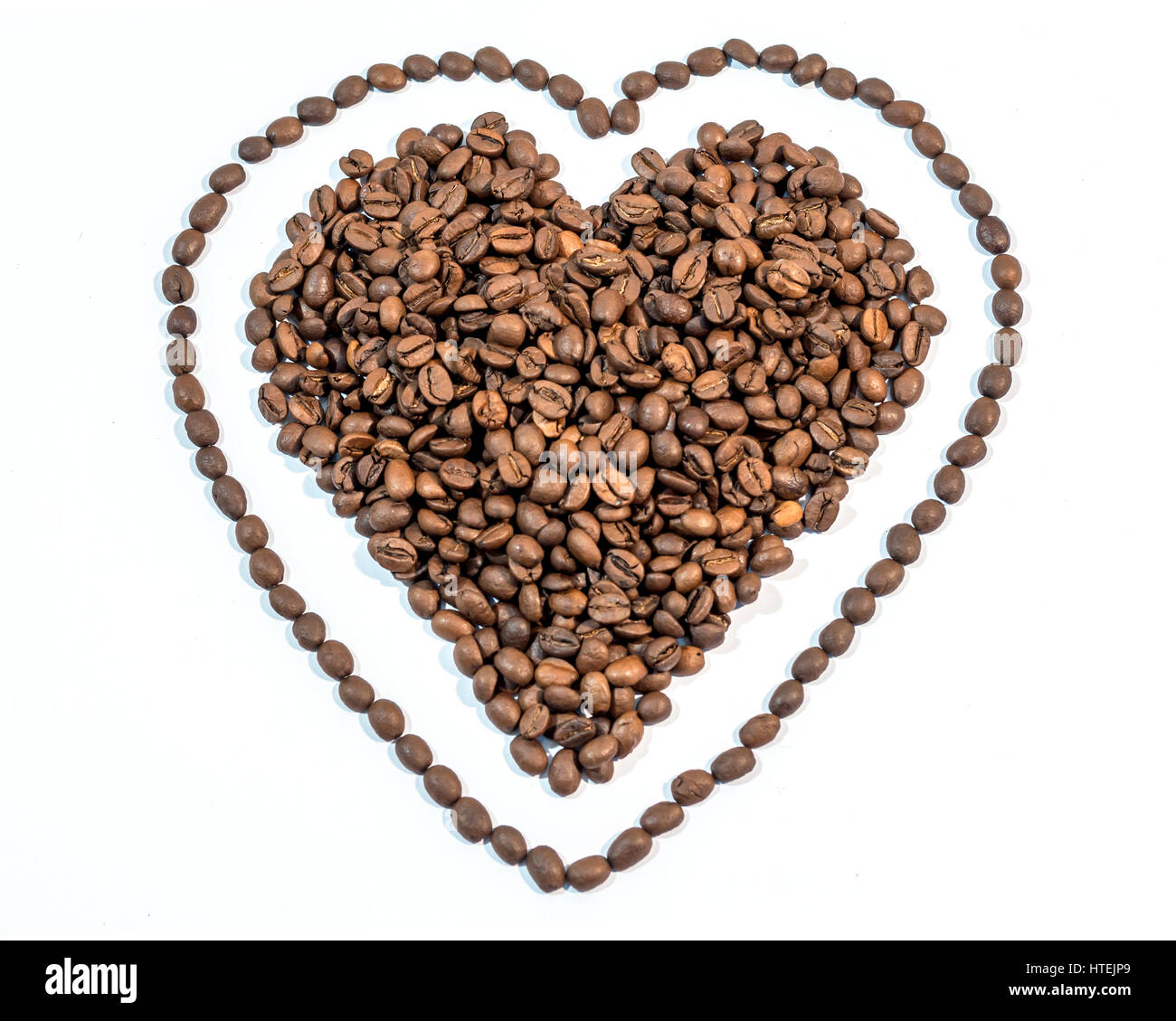 Coffee beans in heart shape with line around heart on white background ...
