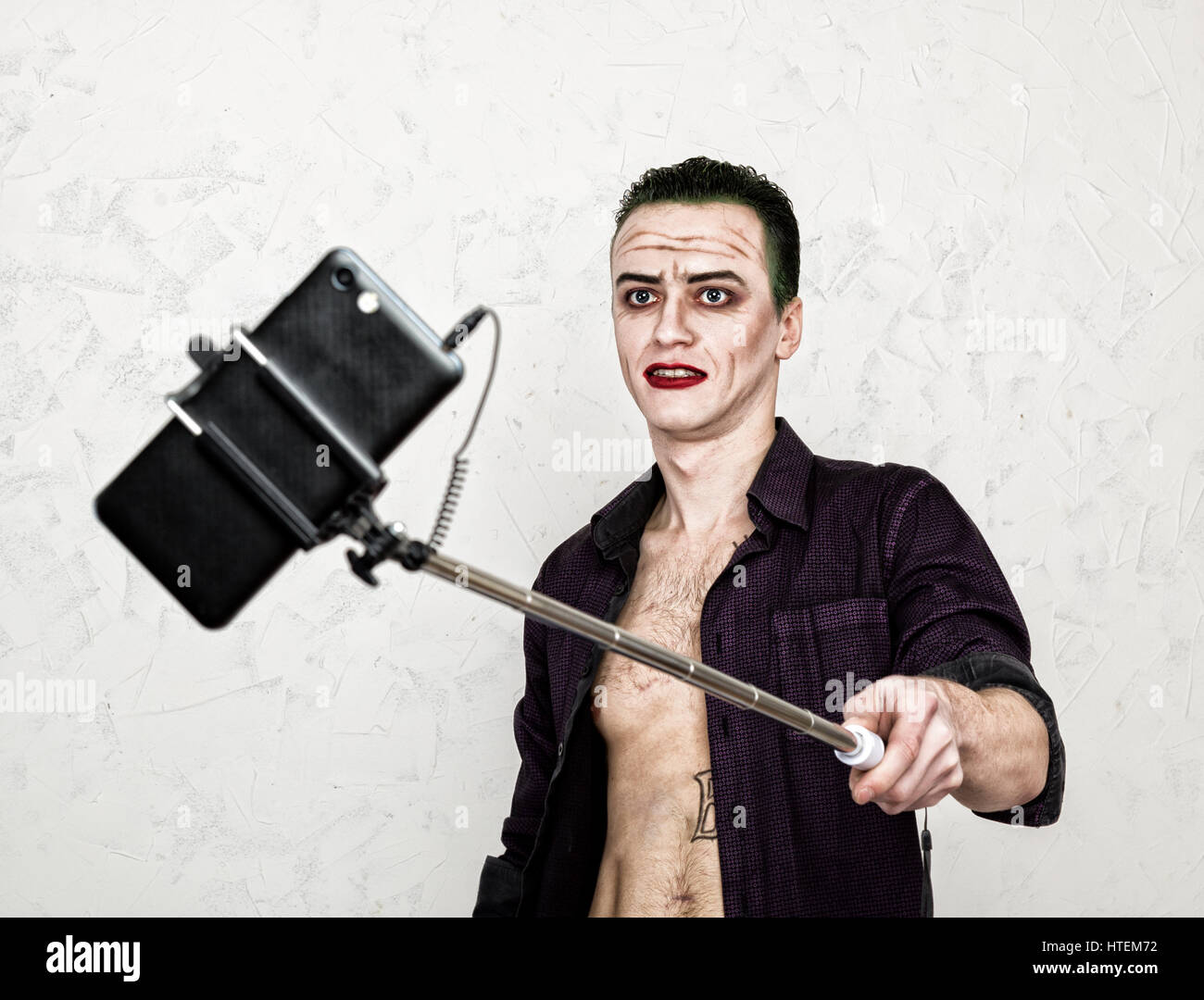 guy with crazy joker face, green hair and idiotic smile. carnaval ...