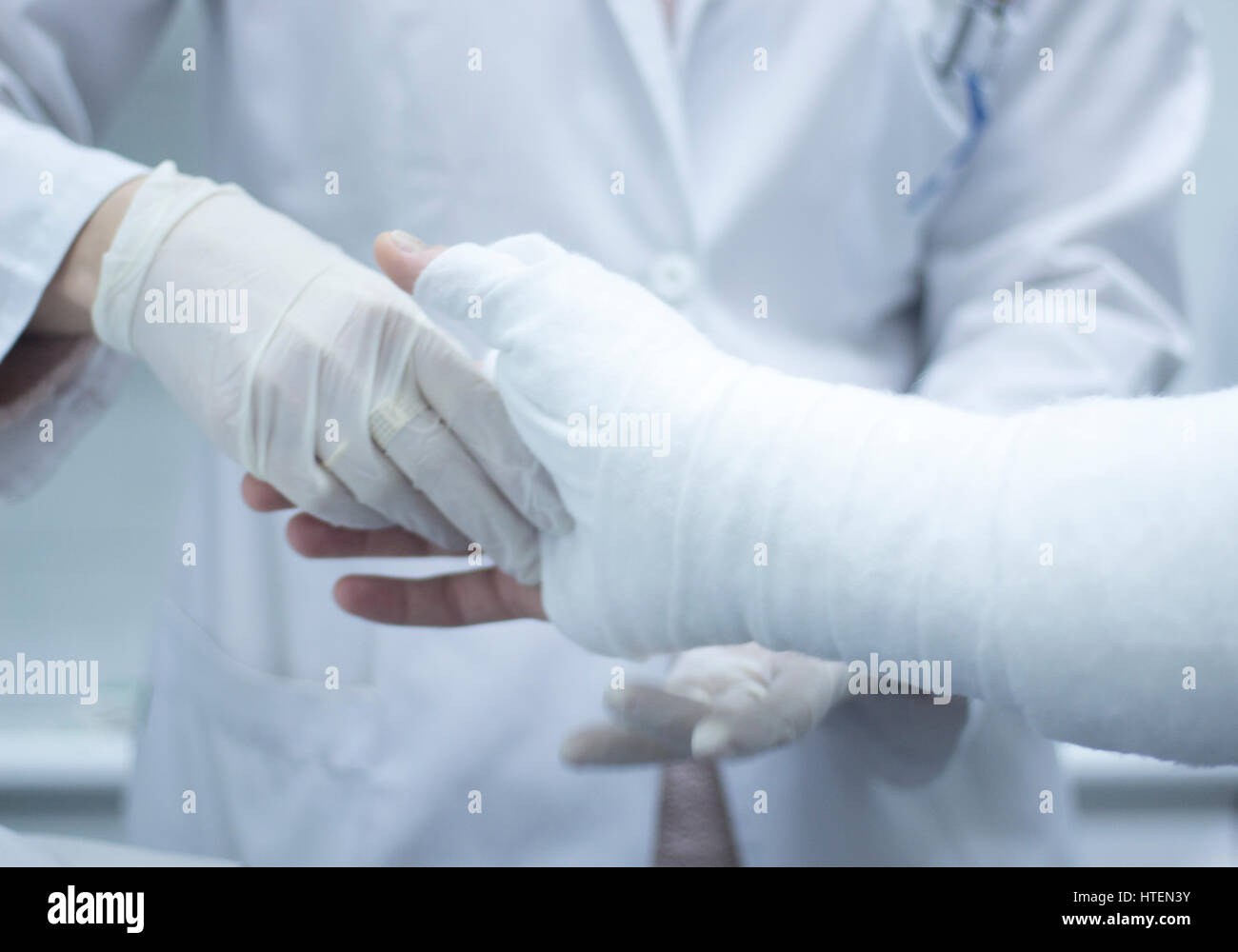 Doctor applying a plaster cast and bandages to patient forearm and ...