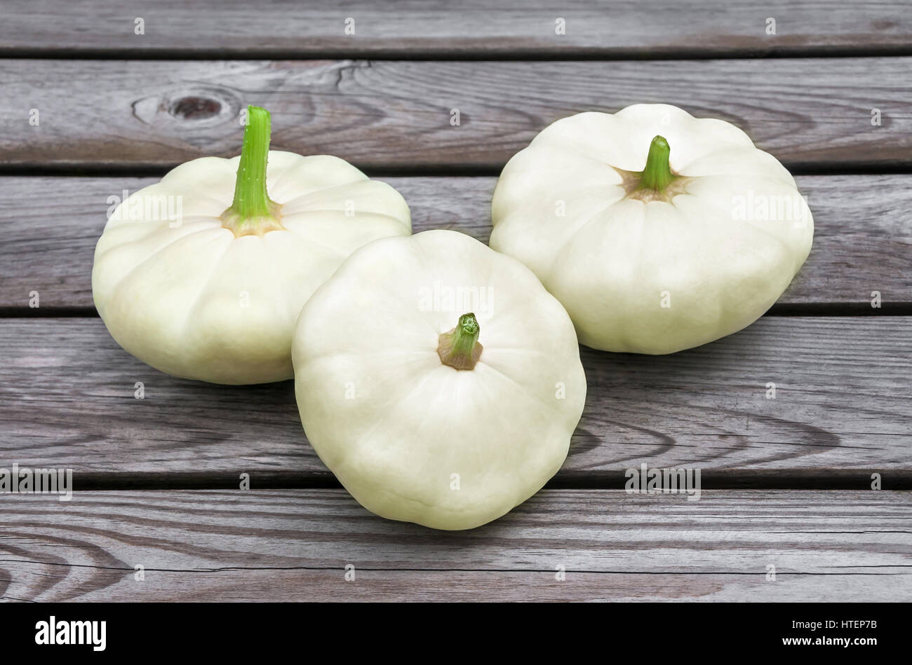 three raw squash on the wooden table Stock Photo - Alamy