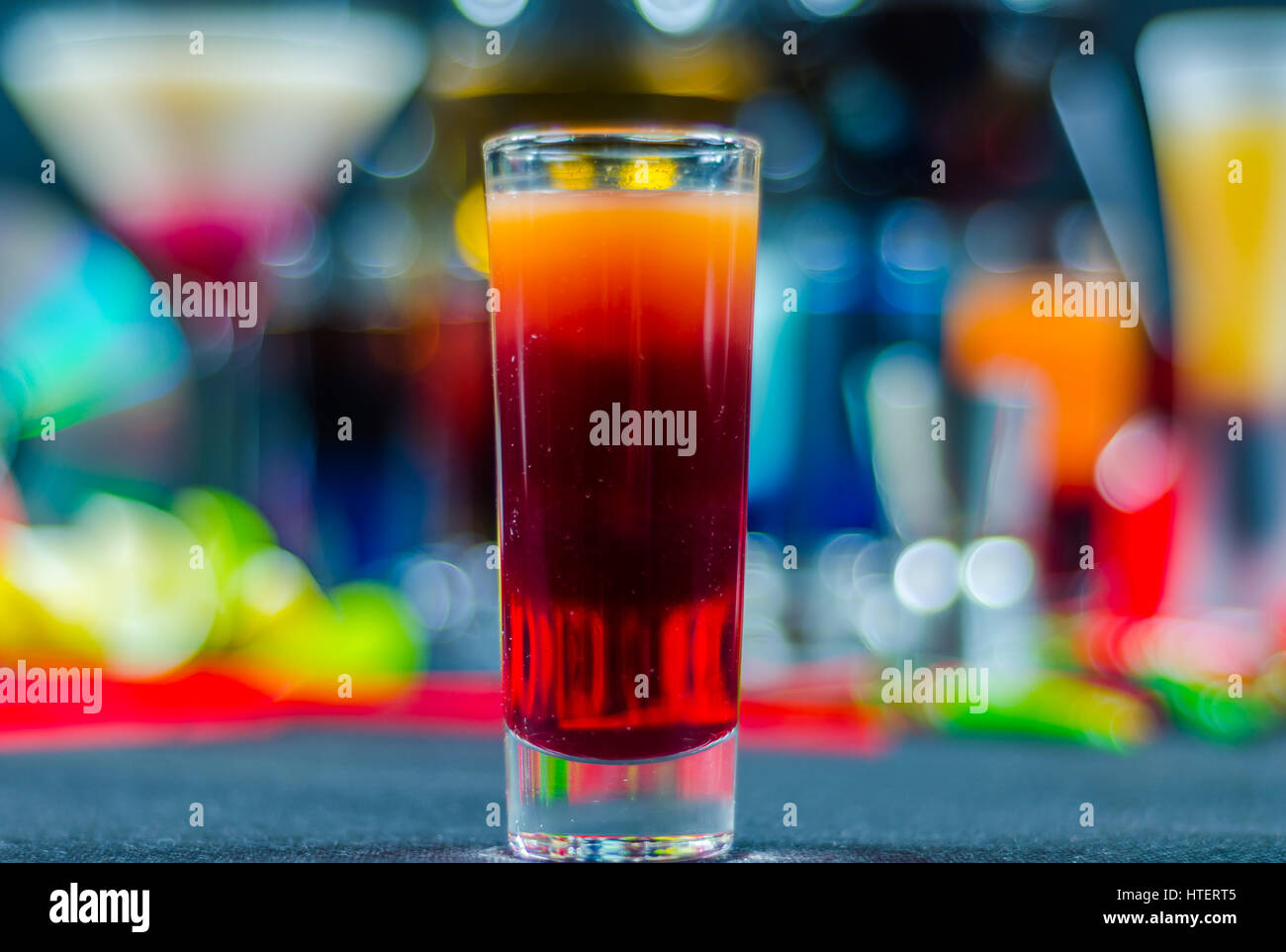 colored drink in glass for shots, a combination of orange with red ...