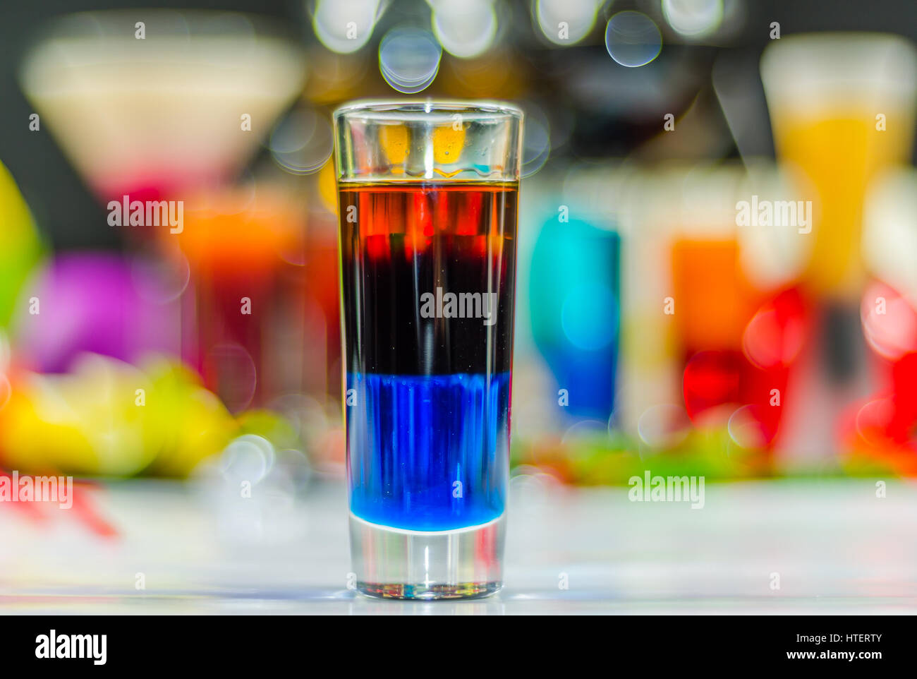 colored drink in glass for shots, a combination of blue with red ...