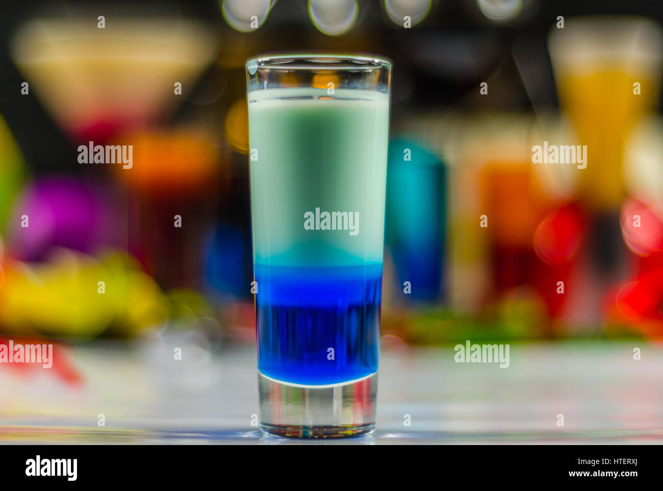 colored drink in glass for shots, a combination of white with blue ...