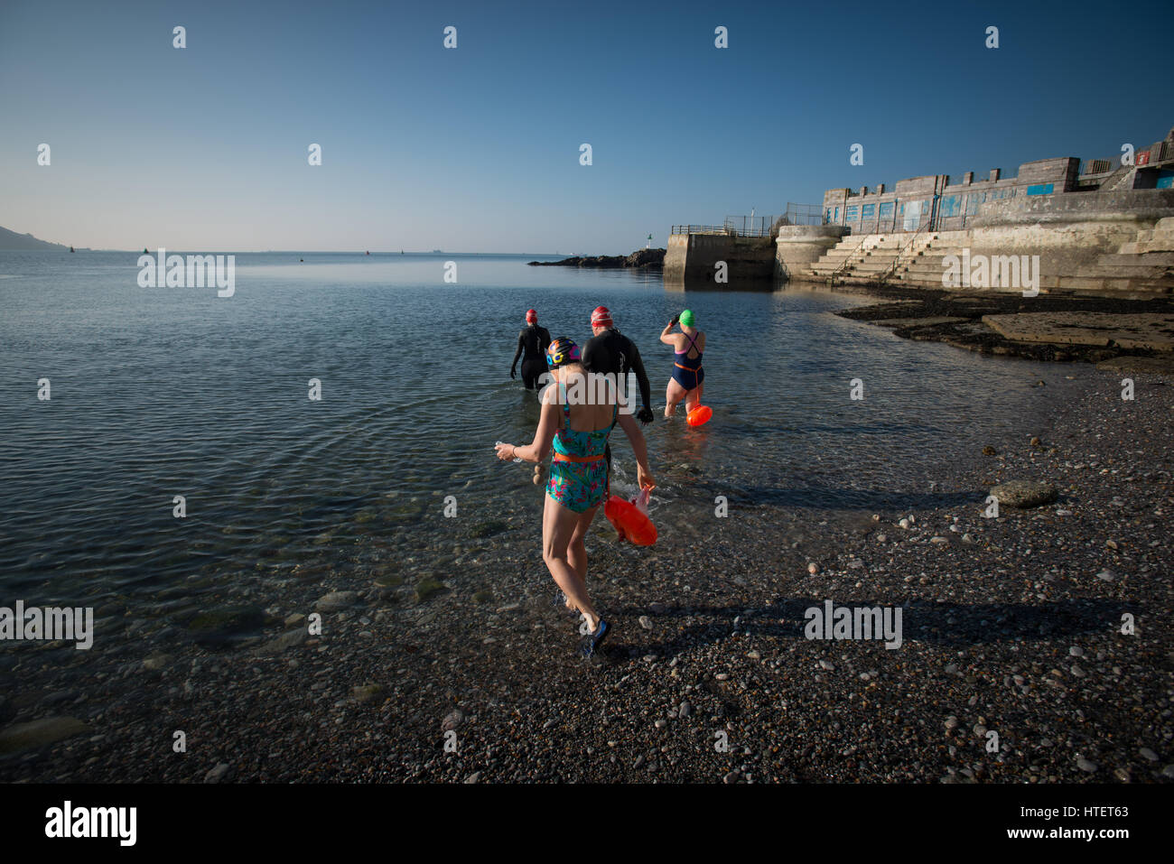 Plymouth, Devon, UK. 21st March 2016. Sea swimmers go for a swim in ...