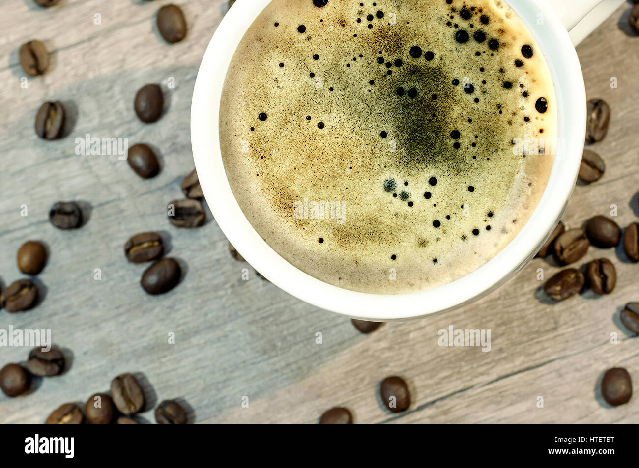 Cup of hot drink with coffee beam on wooden table Stock Photo - Alamy