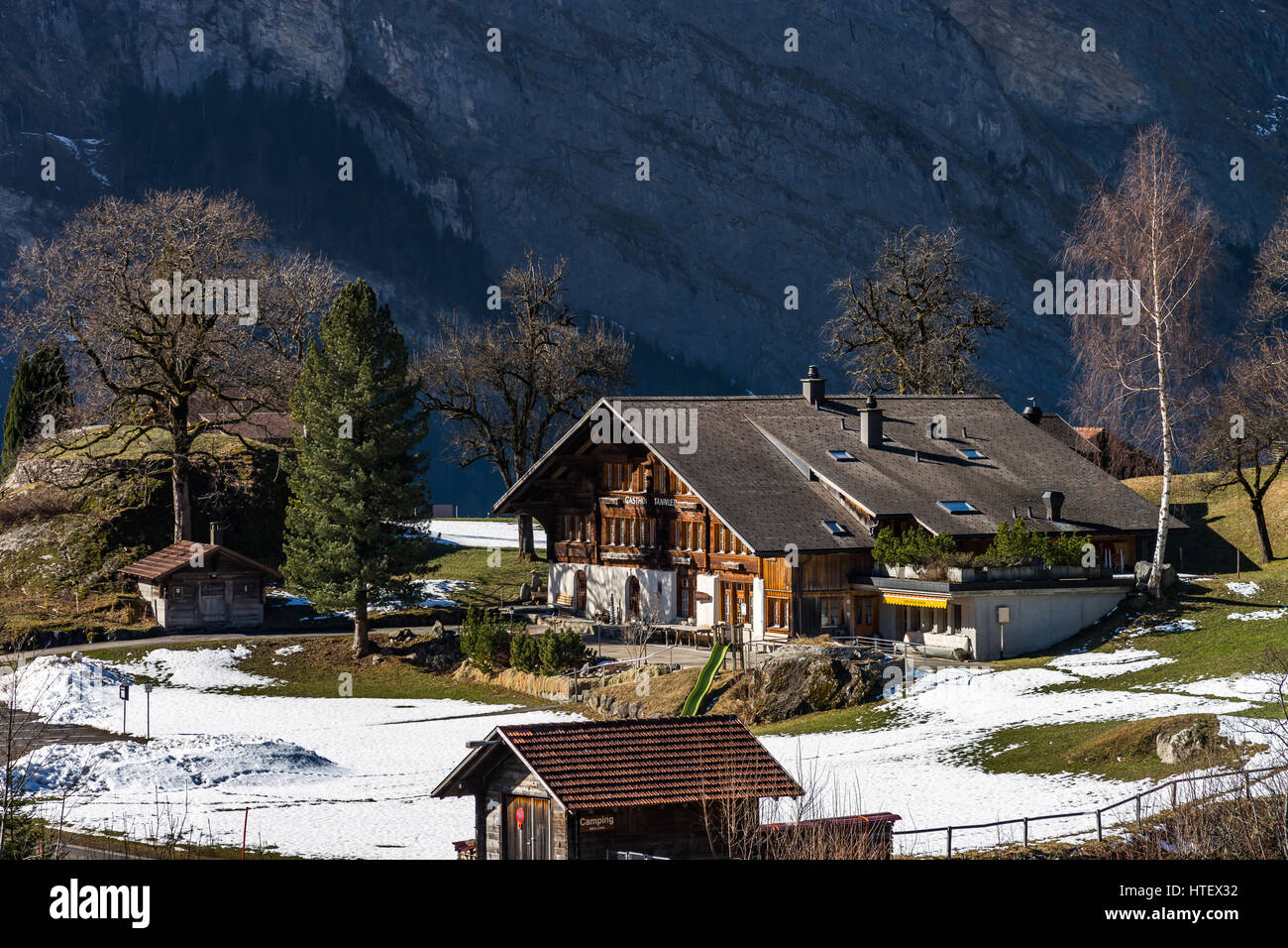 Alpine natural landscape with green fields, high rocks and white clouds ...
