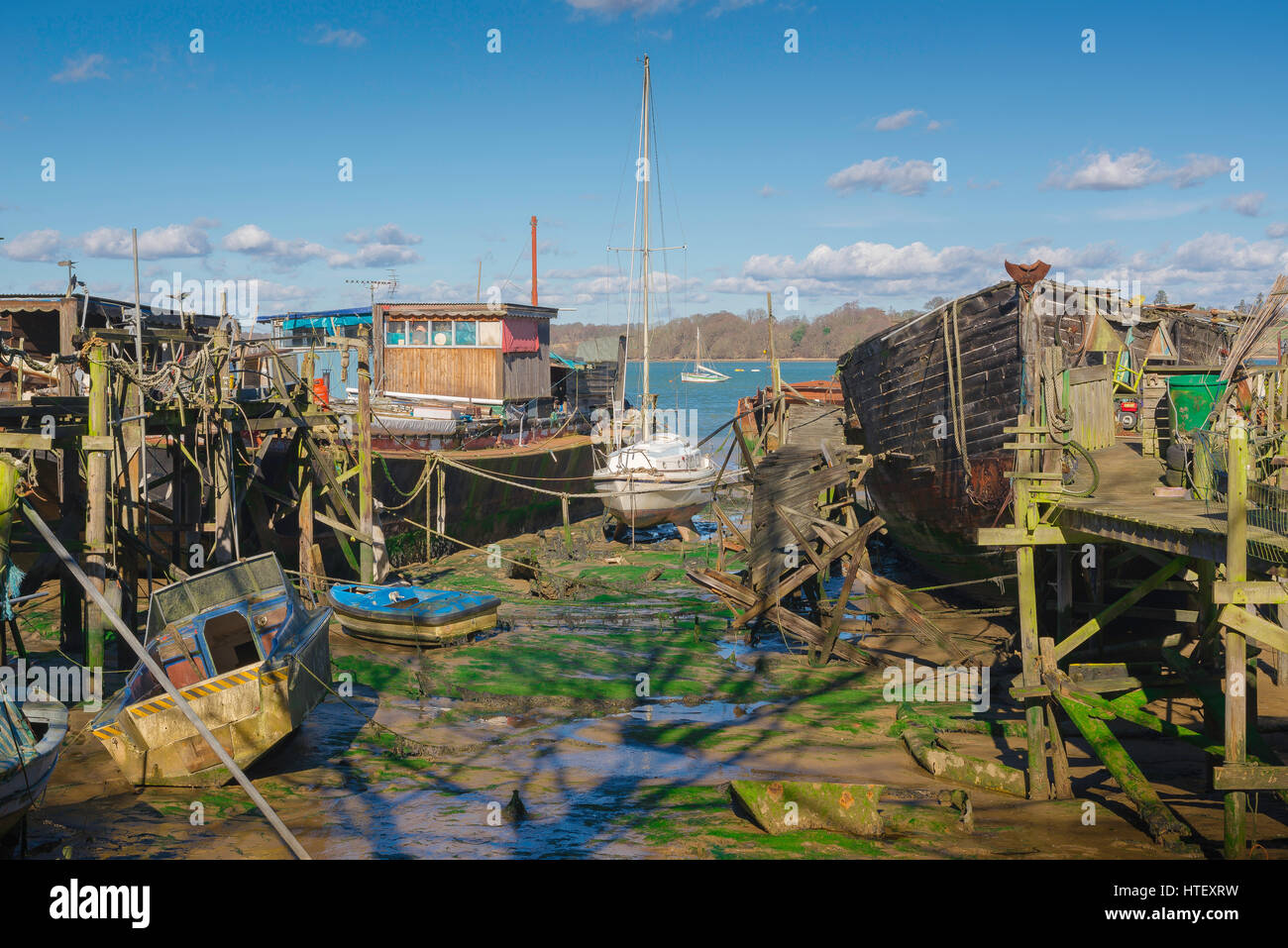 Pin Mill Suffolk, view of a dilapidated jetty and abandoned boats along ...