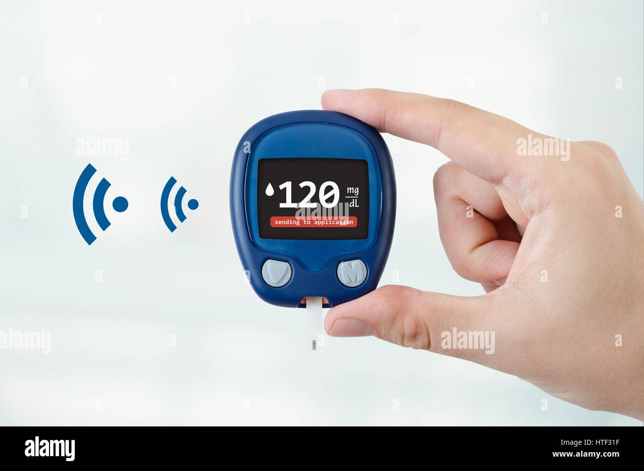 Hand holding glucometer with wireless module. Application for diabetes ...