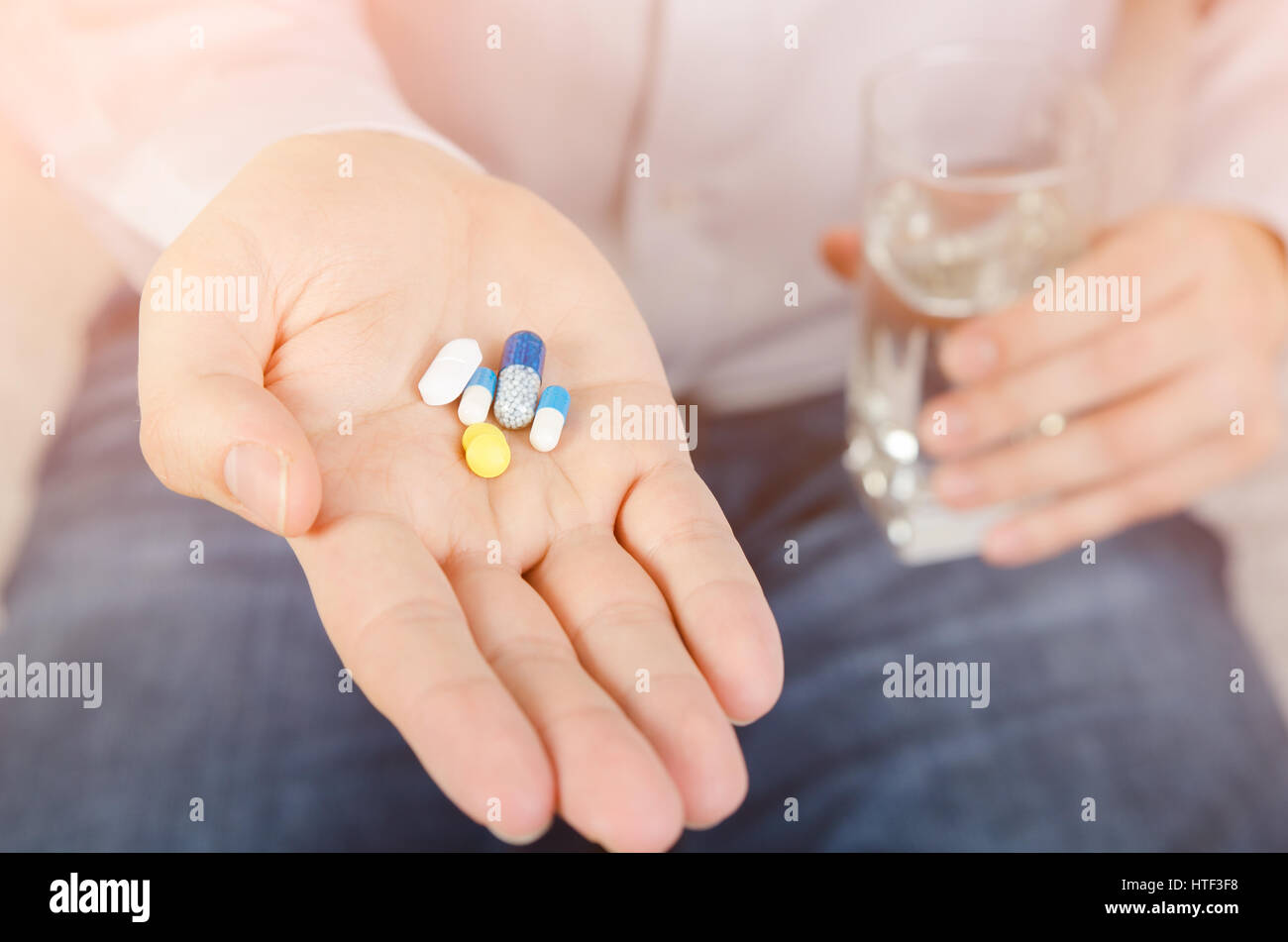Person taking different types of drugs. pills palm holding water glass ...