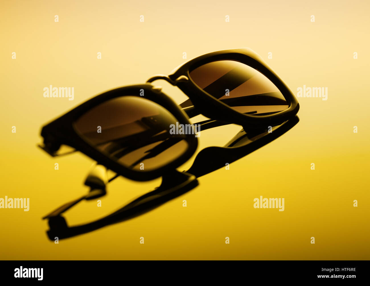 Sunglasses on a gradient background tinted in yellow Stock Photo - Alamy