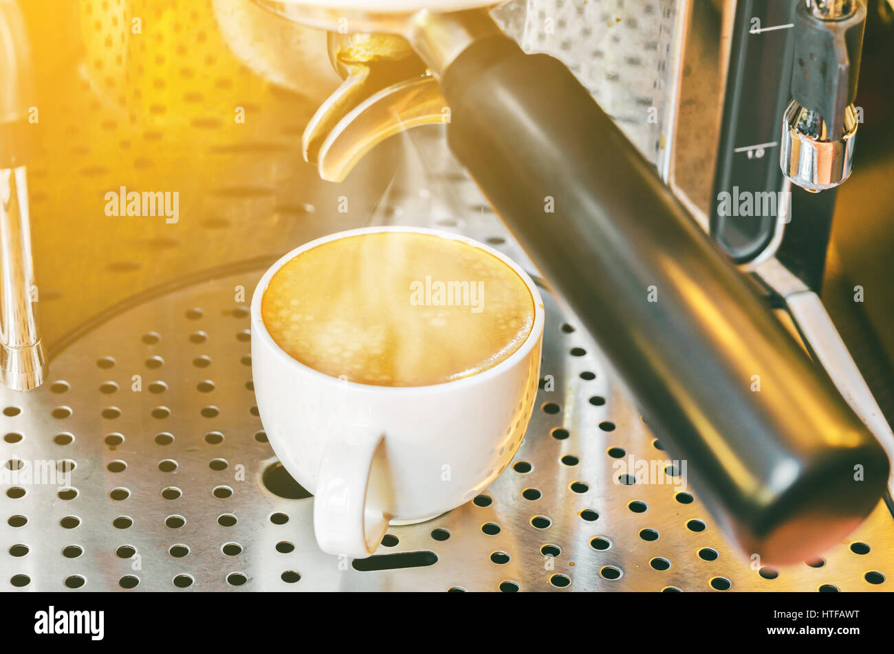 Professional coffee machine making espresso in a cafe with smoke and ...