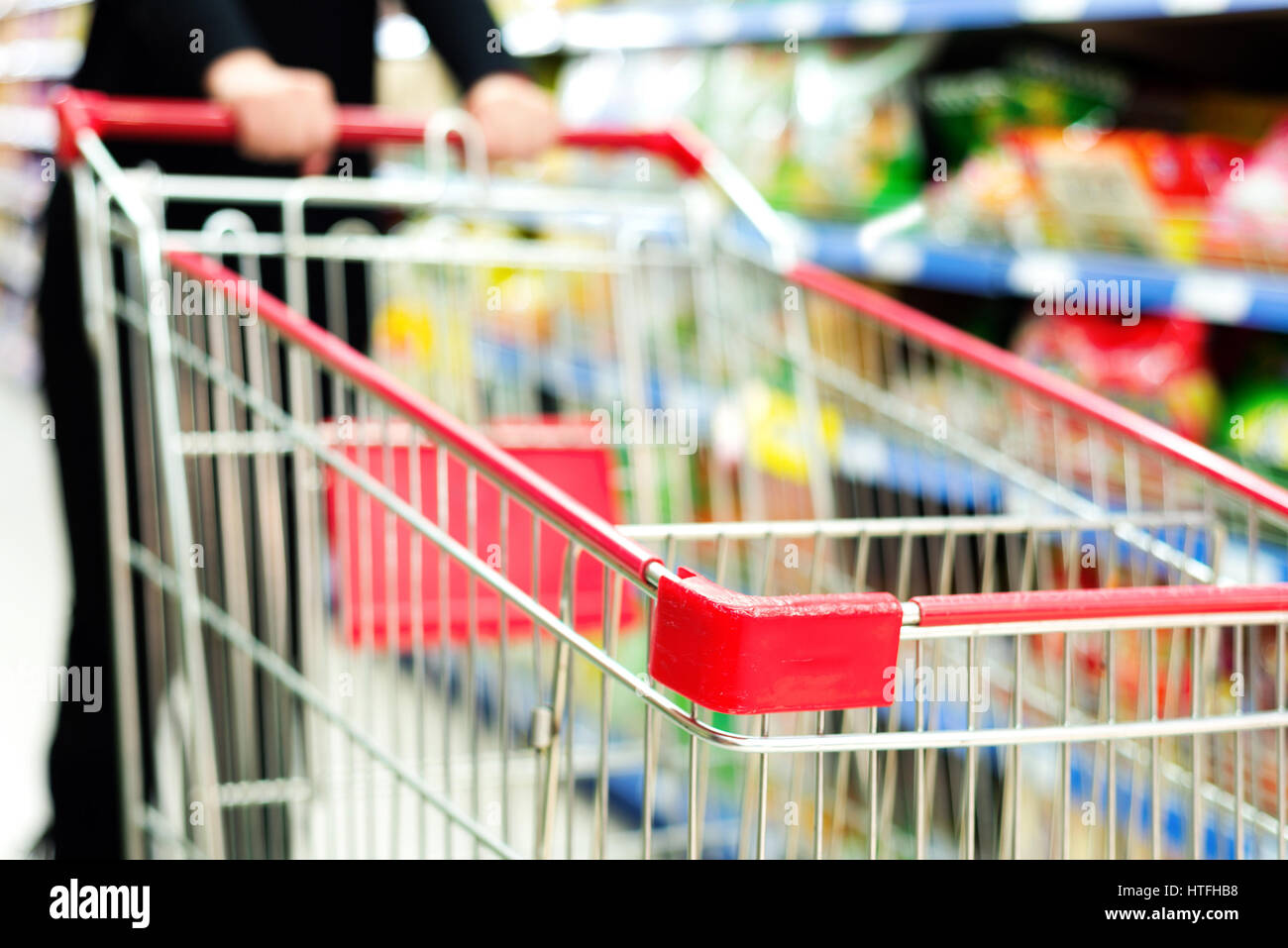 Lady pushing a shopping cart in the supermarket Stock Photo - Alamy