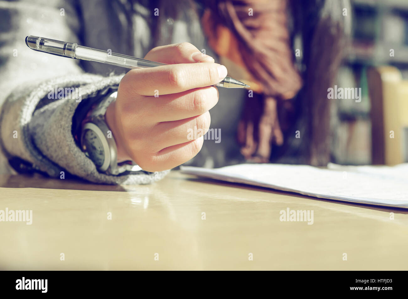 Beautiful girl writing in a library Stock Photo - Alamy