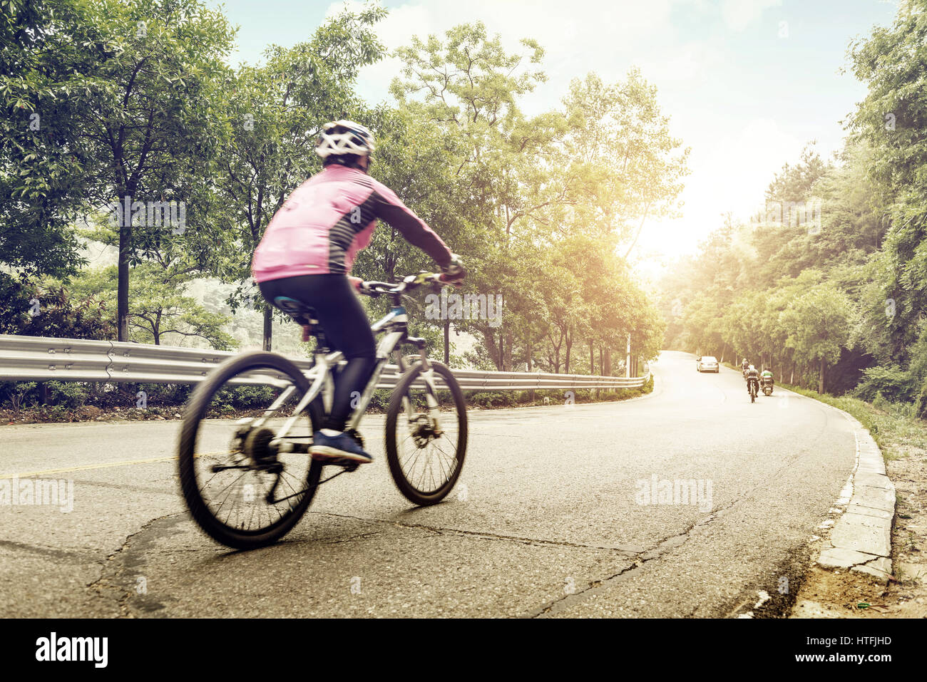 Cyclist riding a bike on an open road Stock Photo - Alamy