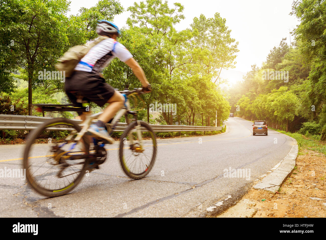 Cyclist riding a bike on an open road Stock Photo - Alamy